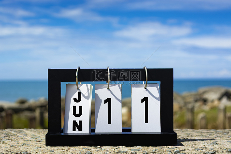 6 月 11 日日历日期文本在木制框架上，海洋背景模糊。高清摄影大图-千库网