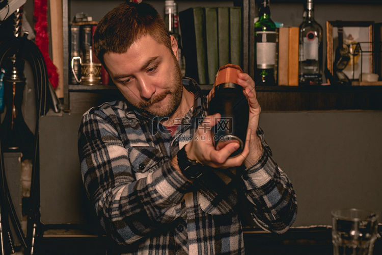 调酒师在调酒器中搅拌清爽鸡尾酒的配料高清摄影大图-千库网