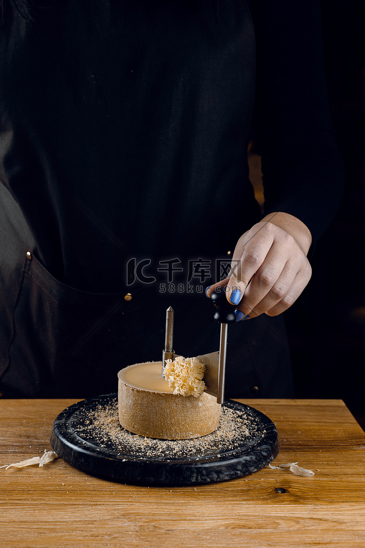 使用 girolle 刀剃掉 tete de moine 奶酪。高清摄影大图-千库网