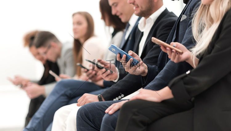 一群年轻人坐在队列里等待高清摄影大图-千库网