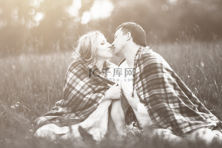 幸福的夫妻 — 孕妇和她的丈夫在公园里盖着一条温暖的毯子高清摄影大图-千库网