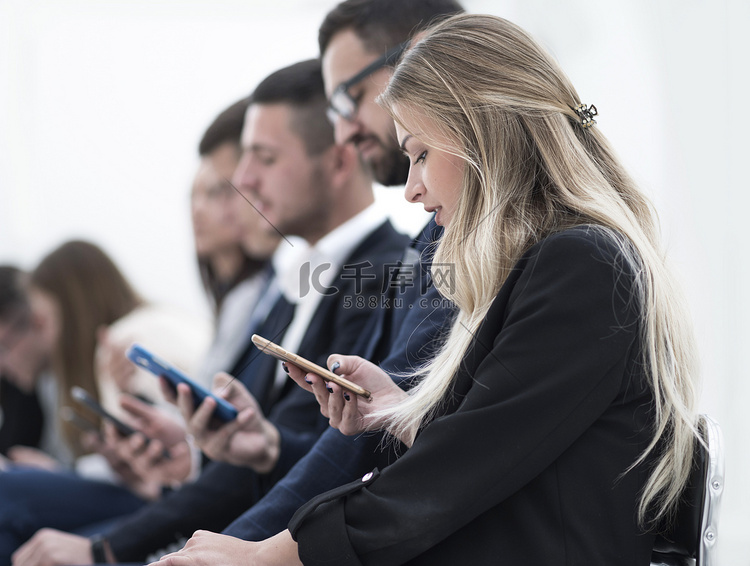 一群年轻人在排队等待，坐在队列中高清摄影大图-千库网