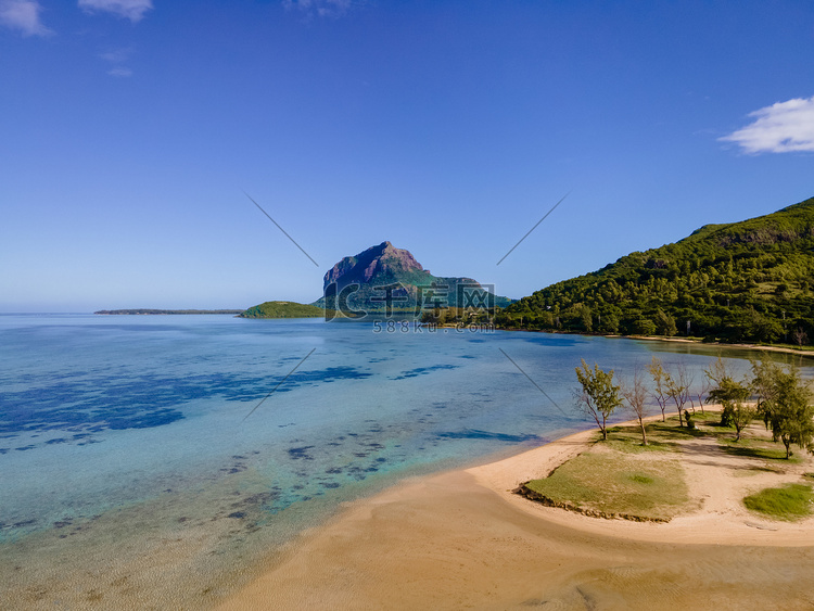 Le Morne 海滩毛里求斯，带棕榈树和白色沙滩蓝色海洋的热带海滩和带雨伞的沙滩床、太阳椅和遮阳伞在热带海滩的棕榈树下，Le Morne ...