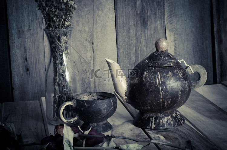 椰子壳、干花的水壶杯水。木质背景高清摄影大图-千库网