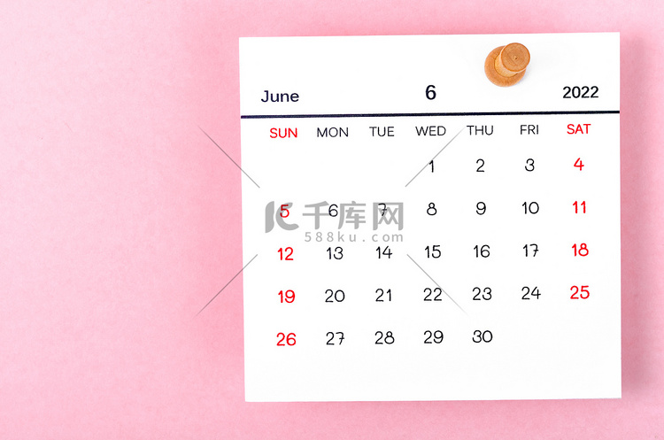 2022 年 6 月日历卡和粉红色背景的木制图钉。高清摄影大图-千库网