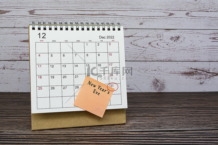 2022 年 12 月的日历在木桌上，日期圈和便利贴上的文字。高清摄影大图-千库网