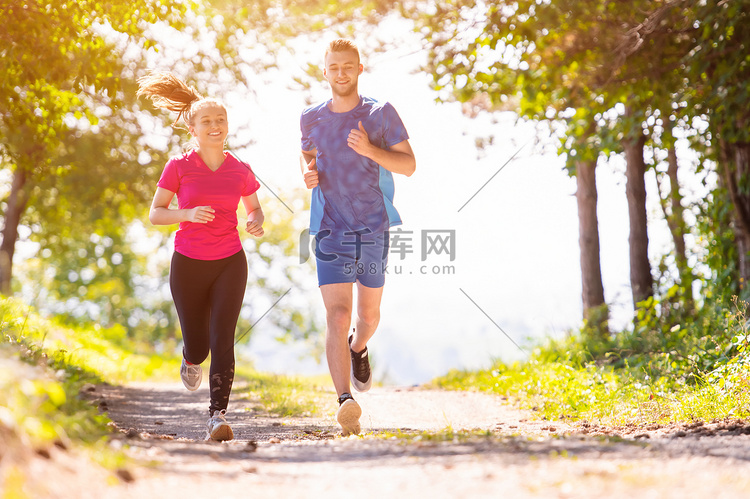 年轻夫妇在阳光明媚的日子在大自然中慢跑高清摄影大图-千库网