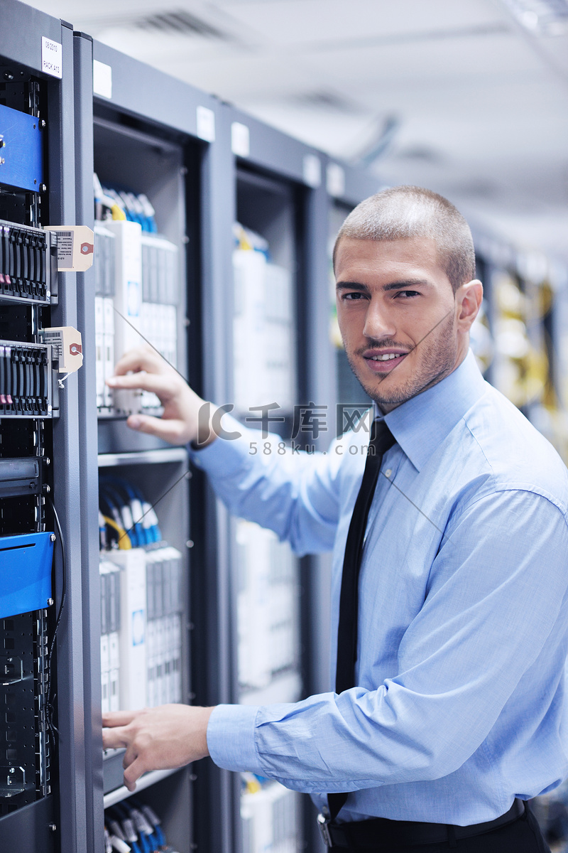 数据中心服务器机房的年轻 IT 工程师高清摄影大图-千库网
