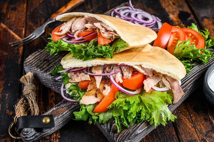 希腊陀螺包裹在皮塔面包中，配以蔬菜和酱汁。高清摄影大图-千库网