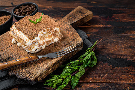 意大利甜点提拉米苏蛋糕，木板上有可可和薄荷。高清摄影大图-千库网