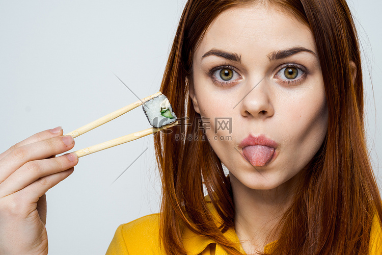 浅色背景下用日本筷子吃寿司的女人高清摄影大图-千库网