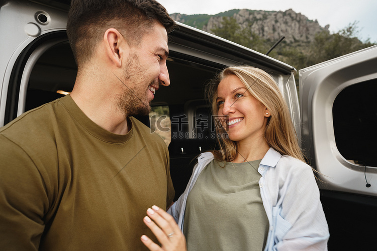 在公路旅行中坐在汽车后备箱里的年轻快乐夫妇高清摄影大图-千库网