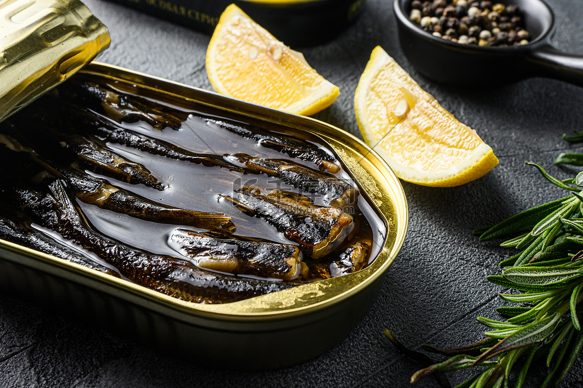 在灰色纹理的石桌上打开罐头的顶视图，在黑色 bpwl 中用香草迷迭香、柠檬和胡椒关闭侧面视图。高清摄影大图-千库网