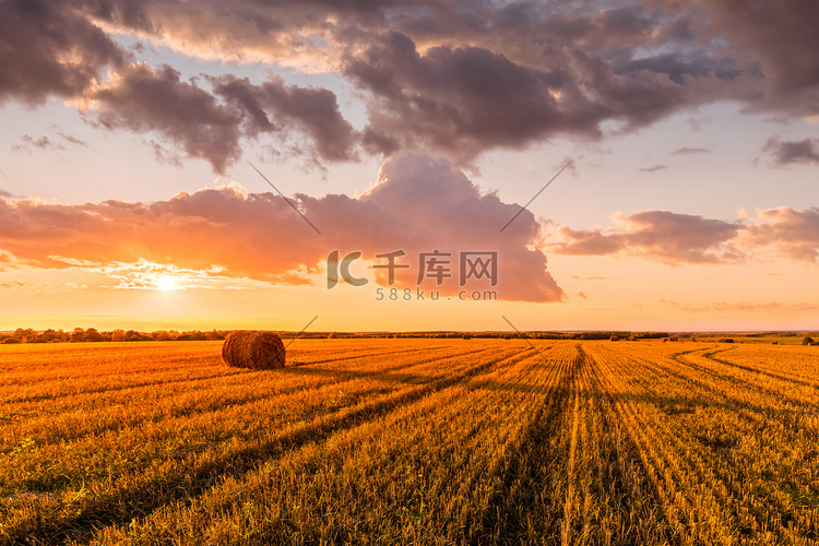 在秋天的季节，田野上的日落场景与干草堆。高清摄影大图-千库网