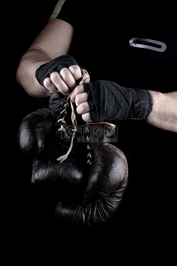 男士手中的一双非常旧的拳击运动手套高清摄影大图-千库网