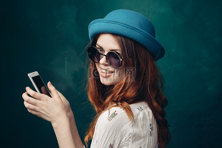 戴蓝帽的时尚女性手握电话通信技术高清摄影大图-千库网