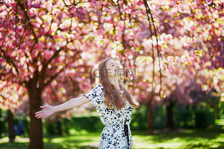 美丽的年轻女子在盛开的春天公园高清摄影大图-千库网