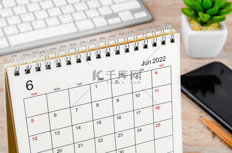 2022 年 6 月木桌上的台历。高清摄影大图-千库网