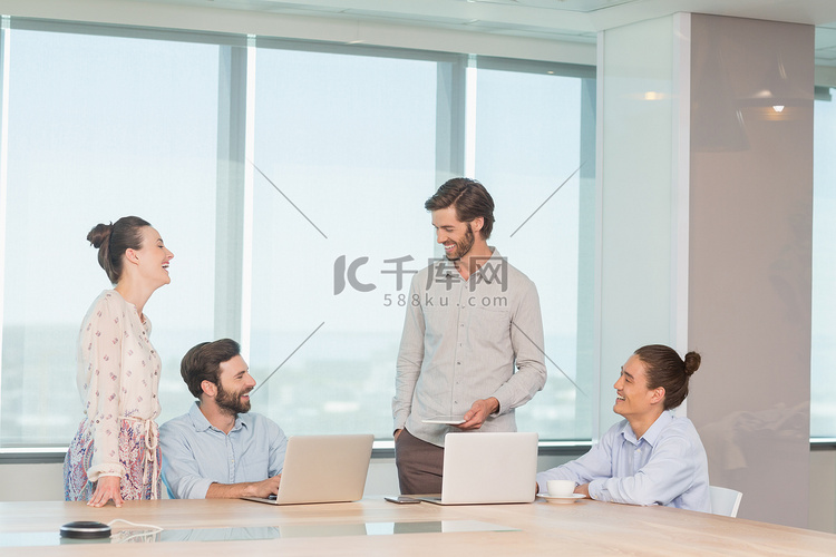 微笑的企业高管在会议室互相讨论高清摄影大图-千库网