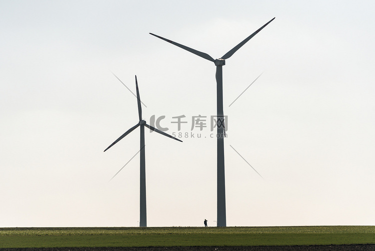两个风电场和一个显示这些风电场规模的人体轮廓高清摄影大图-千库网