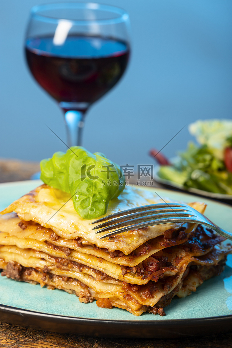 蓝盘上的新鲜千层面的一部分高清摄影大图-千库网