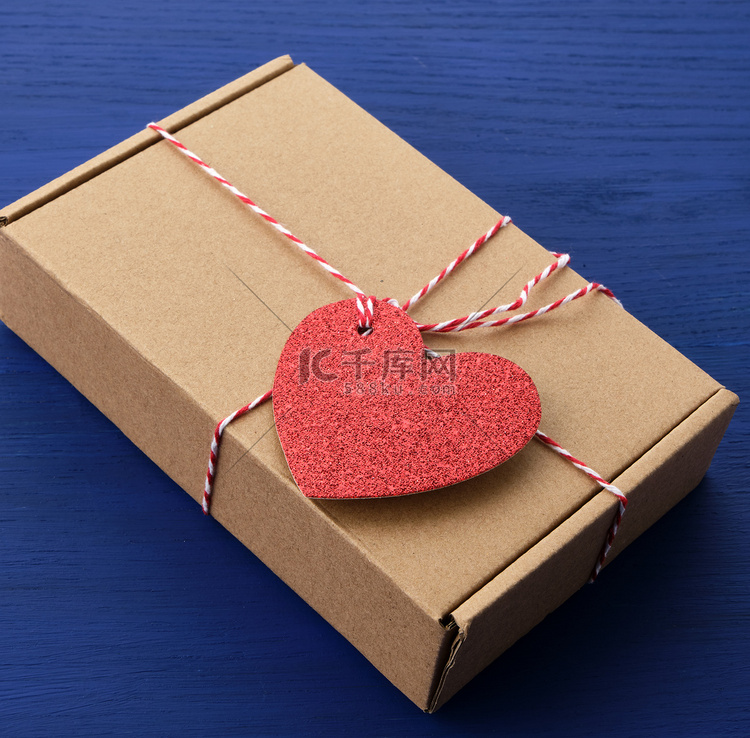 长方形棕色盒子，上面绑着礼物和红纸心高清摄影大图-千库网
