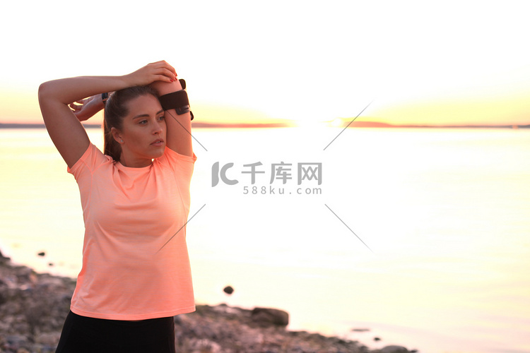 小女孩在户外热身，锻炼前伸展三头肌和颈部肌肉高清摄影大图-千库网