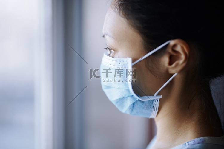 呆在家里戴防护外科口罩的妇女高清摄影大图-千库网