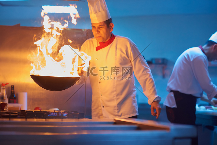 酒店厨房的厨师用火准备食物高清摄影大图-千库网