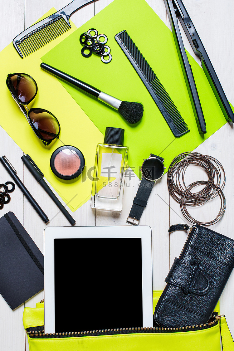 化妆品和女性配饰从白色背景的绿色手提包中掉下来。高清摄影大图-千库网