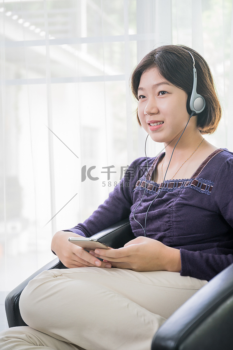 年轻的亚洲女性短发在客厅听音乐高清摄影大图 千库网