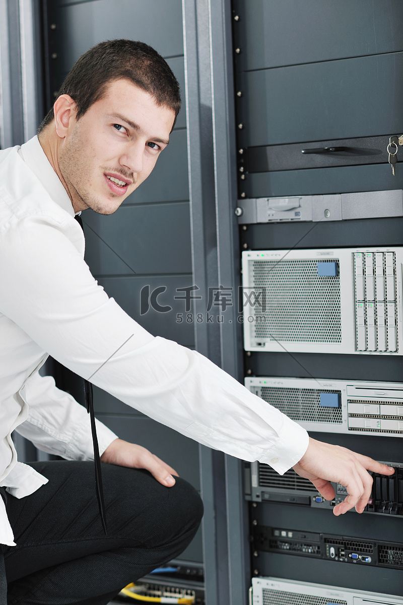 数据中心服务器机房的年轻 IT 工程师高清摄影大图-千库网