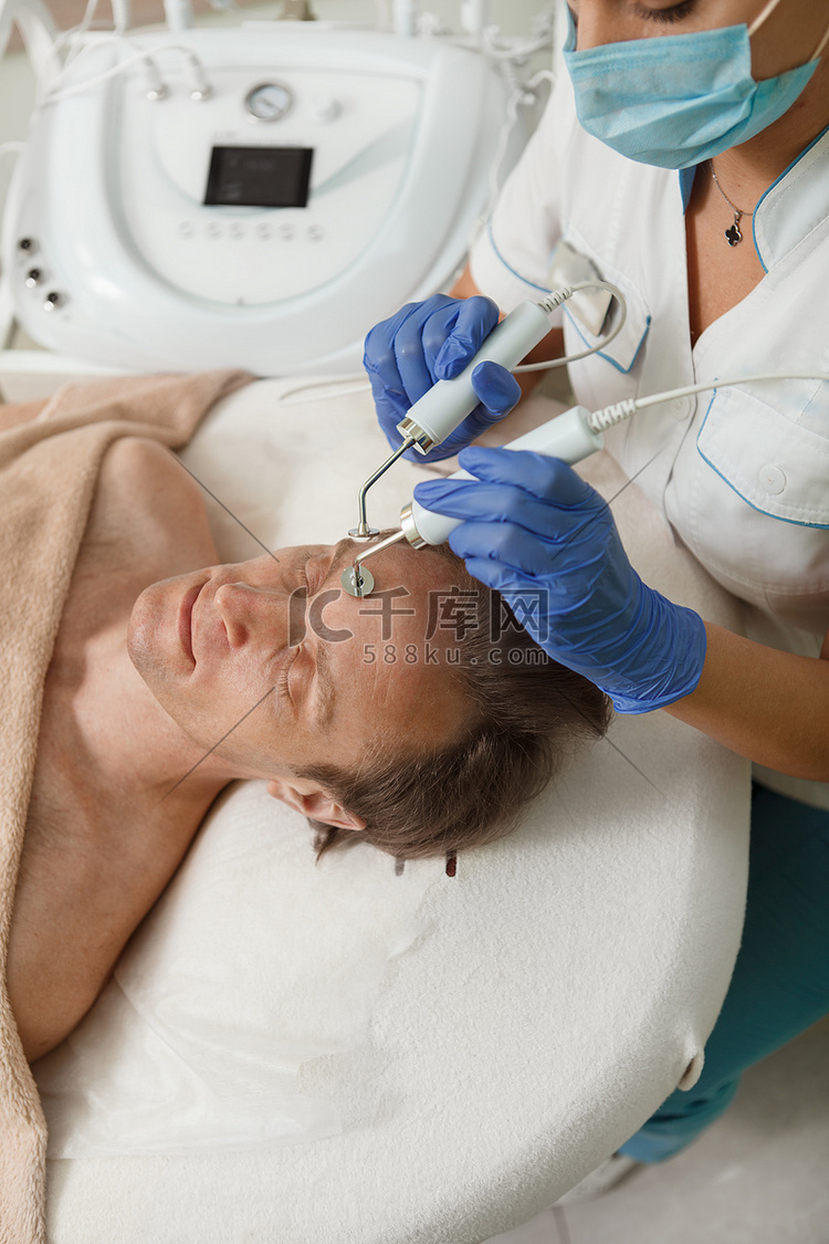 成熟男子在美容诊所接受面部护肤治疗高清摄影大图-千库网