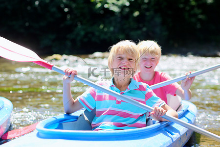 Two happy kids kayaking on the river高清摄影大图-千库网