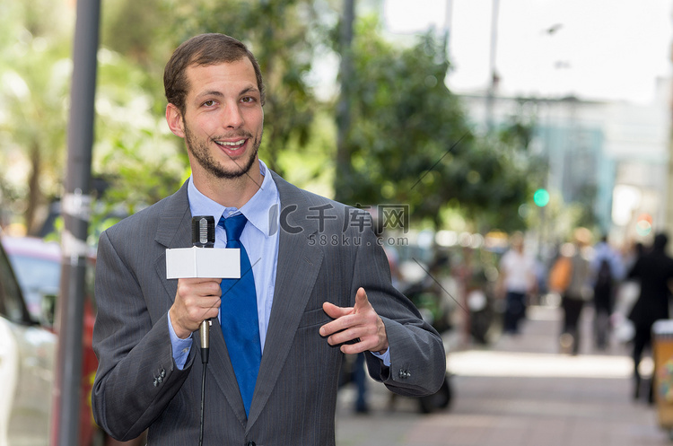 Attractive professional male news reporter wearing grey suit holding ...