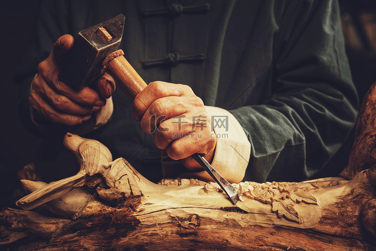认真雕刻的工匠师与工艺品高清摄影大图-千库网