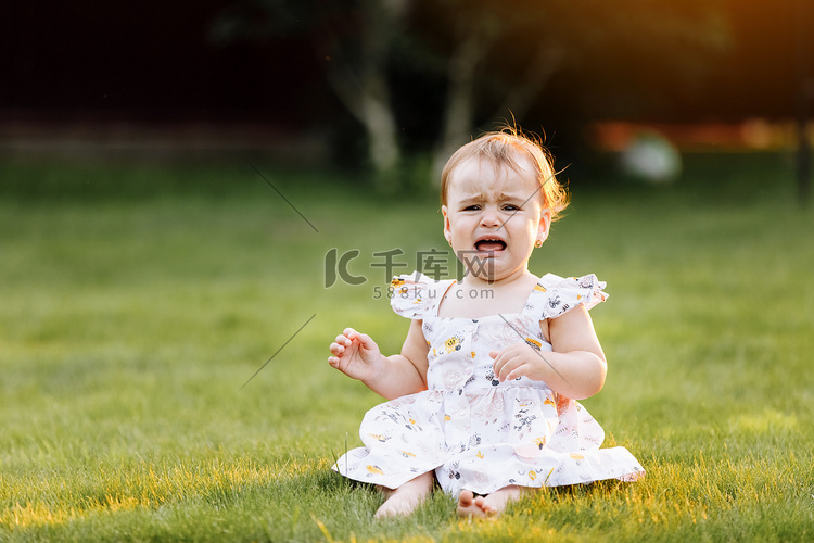 crying baby toddler girl on grass outdoors. Child feelings and emotions ...
