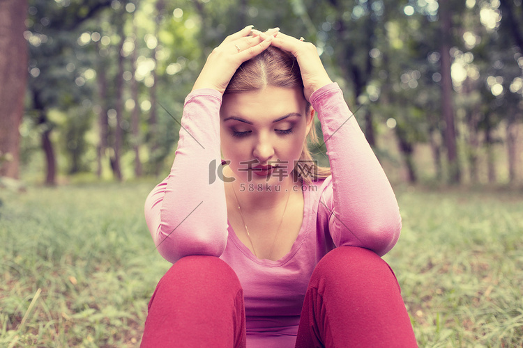 portrait stressed sad young woman sitting outdoors on summer day in ...
