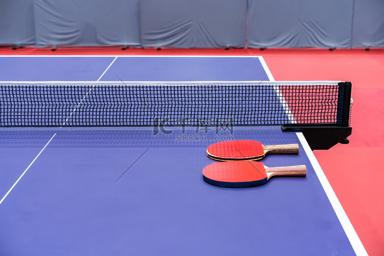 Two pingpong table tennis rackets for playing are laid on next to net ...