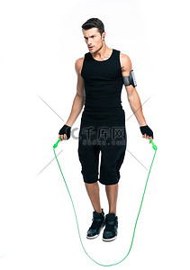 Handsome man jumping with skipping rope 高清摄影大图-千库网