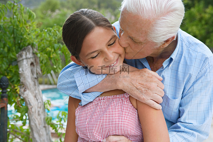 grandfather and his granddaughter hugging and kissing高清摄影大图-千库网