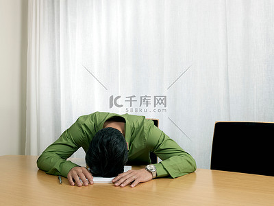 办公桌旁的生意人头在桌子上高清摄影大图-千库网