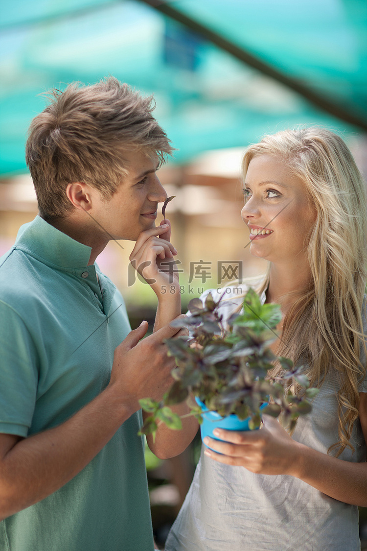 夫妇在苗圃里闻植物的味道高清摄影大图-千库网