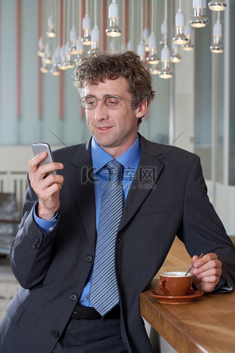 酒吧里的生意人看着他的手机高清摄影大图-千库网