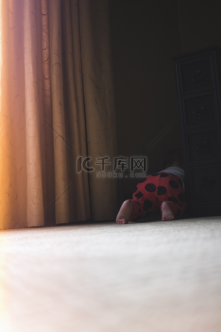 在窗帘后爬行的蹒跚学步的女孩高清摄影大图-千库网