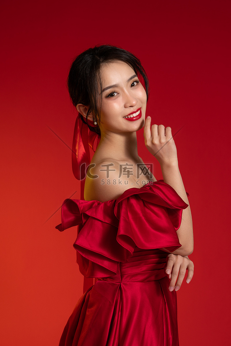 新年气氛红色背景下的一位亚洲青年女性高清摄影大图-千库网