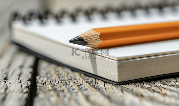 在木桌上特写铅笔和螺旋笔记本选择性焦点高清摄影大图-千库网