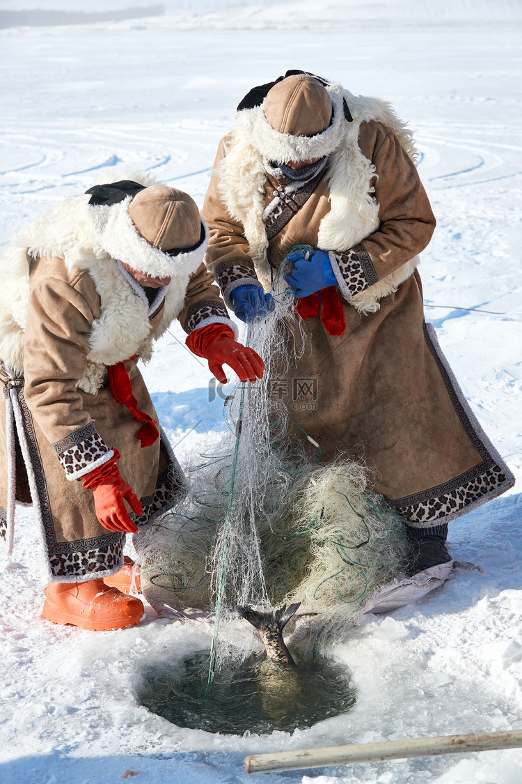 寒冷的冬季在冰冻的湖面上凿冰捕鱼的人们高清摄影大图-千库网