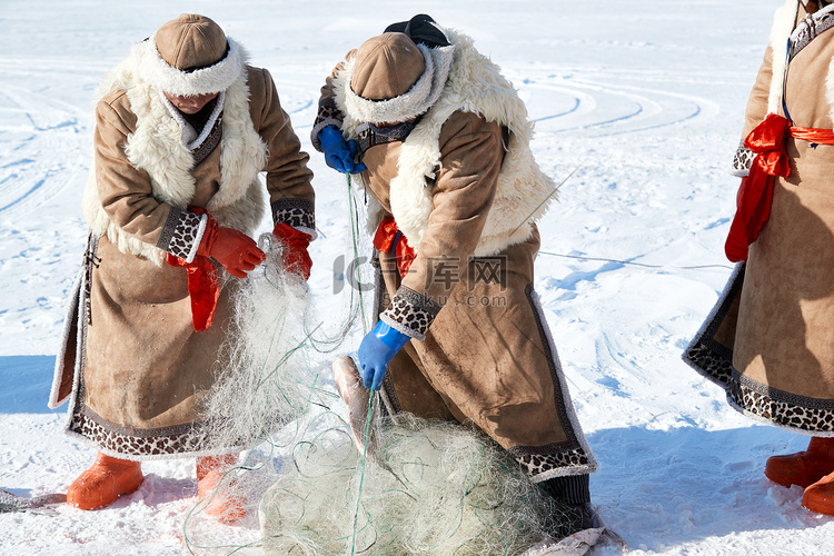寒冷的冬季在冰冻的湖面上凿冰捕鱼的人们高清摄影大图-千库网