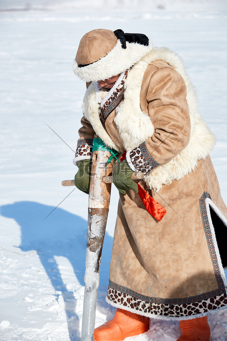 寒冷的冬季在冰冻的湖面上凿冰捕鱼的人们高清摄影大图-千库网